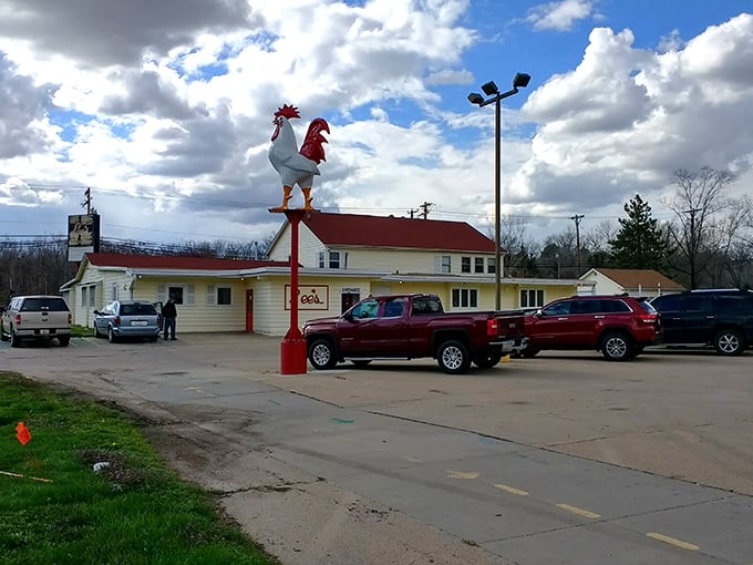 The iconic rooster stands sentinel atop its red pole, beckoning hungry travelers to this unassuming temple of fried chicken perfection in Lincoln.