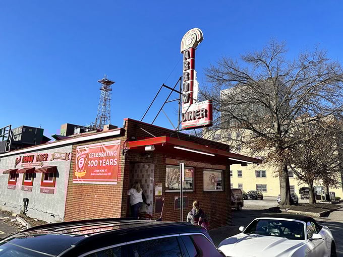 The iconic Red Arrow Diner sign beckons hungry travelers like a neon lighthouse, promising salvation from hunger in downtown Manchester.