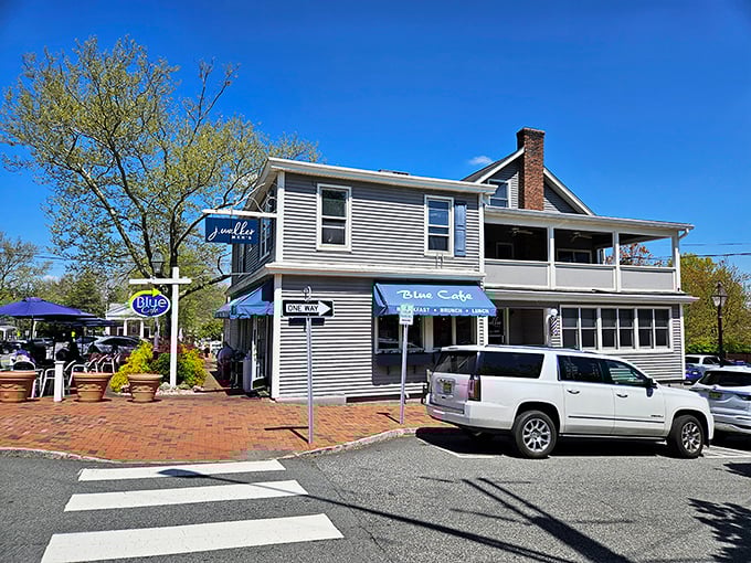 The welcoming blue awnings and vibrant potted plants make Blue Cafe's exterior as inviting as a friend's porch on a perfect summer day.