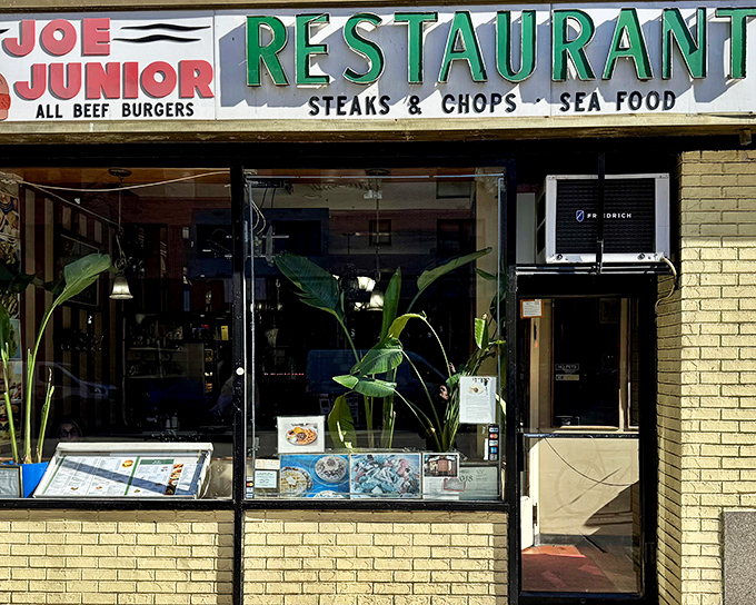 The iconic Joe Jr. sign promises three essential food groups: all-beef burgers, steaks & chops, and seafood. Classic New York diner perfection awaits inside.