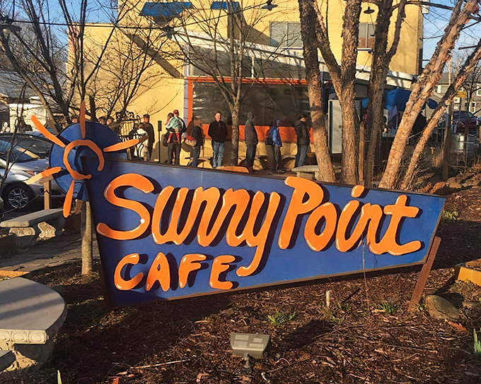 The iconic blue sign says it all – people aren't just waiting for breakfast, they're queuing for a culinary pilgrimage at Sunny Point Café.
