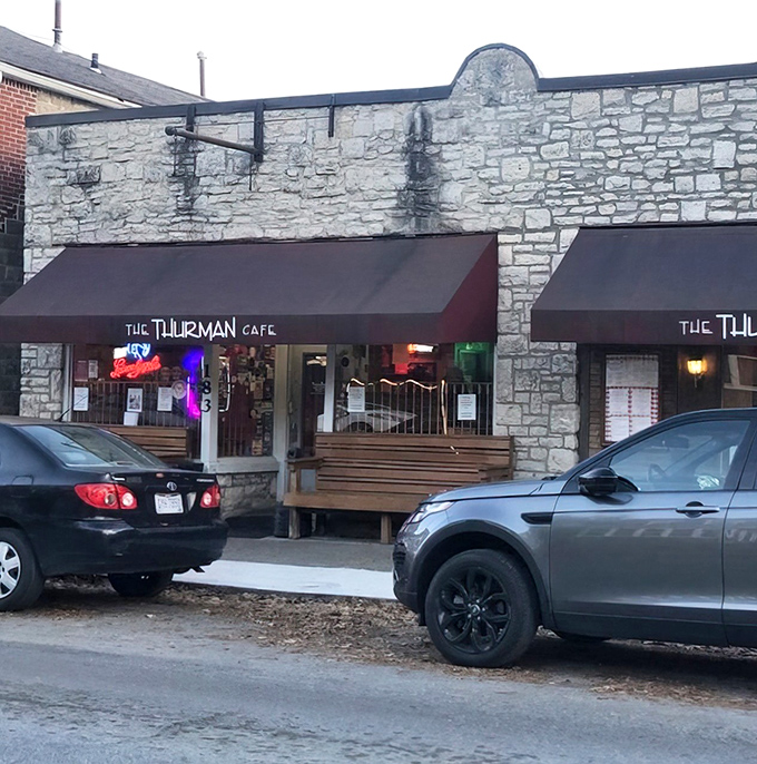 The stone facade and bright red awnings of Thurman Cafe stand like a culinary fortress in Columbus's German Village, promising burger adventures within.