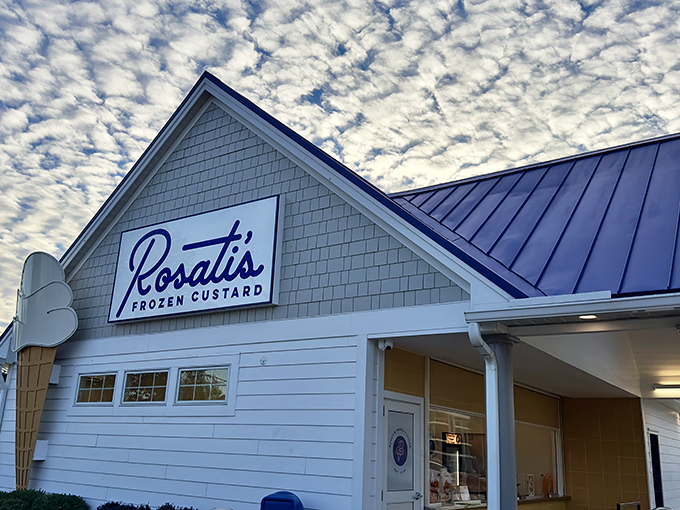 Rosati's glows like a frozen dessert lighthouse at dusk, its neon ice cream cone beckoning weary travelers toward sweet salvation.
