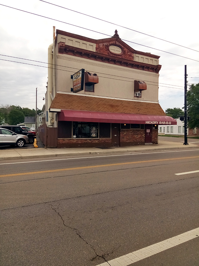 The historic facade of Hickory Bar-B-Q stands like a time capsule on Dayton's streets, its burgundy awning beckoning hungry travelers like a smoky siren call.