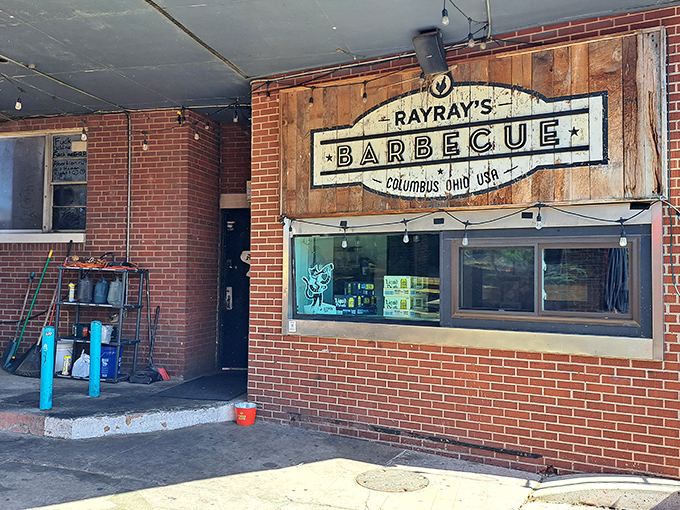 The rustic wooden sign at Ray Ray's speaks barbecue truth: no fancy frills needed when the smoke does all the talking. 