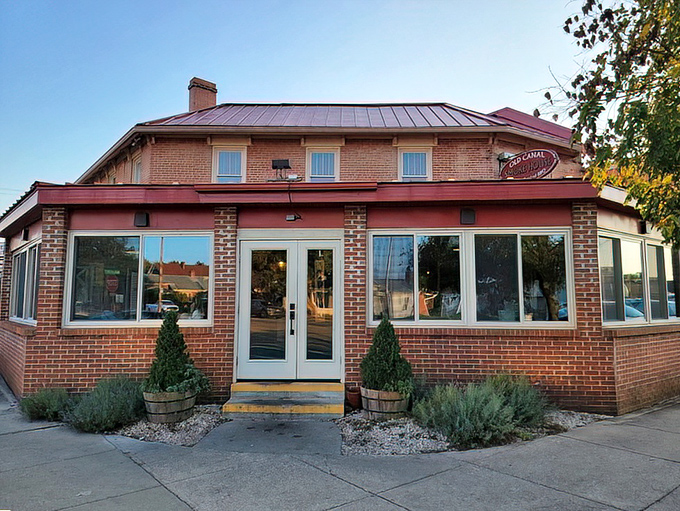 The brick exterior of Old Canal Smoke House welcomes hungry travelers with its warm glow and rustic charm, promising smoky delights within.