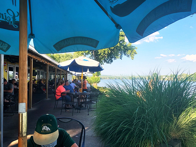 Paradise found: Blue umbrellas frame the perfect riverside dining experience where the Muskingum meets the Ohio. Nature's dining room awaits.
