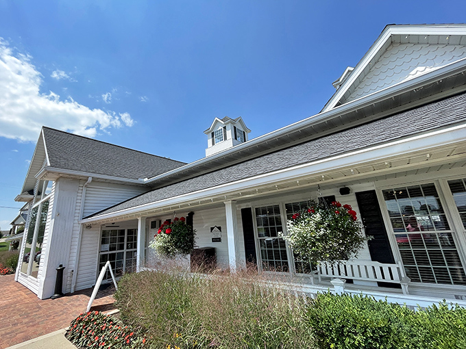The classic white farmhouse exterior welcomes you like an old friend, complete with rocking-chair porch and blooming flowers that practically whisper "come on in."
