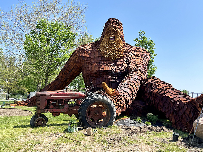 Nelson the Sasquatch lounges casually by his vintage tractor, looking like he's about to ask if you've considered switching to farm-to-table dining options.
