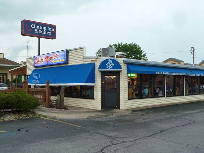 The bright blue awning of Jolly Rogers stands like a maritime beacon on Port Clinton's shoreline, promising seafood treasures within these humble walls.