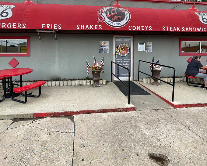 The iconic red awning of Sid's Diner beckons hungry travelers along Route 66 like a culinary lighthouse in a sea of chain restaurants.