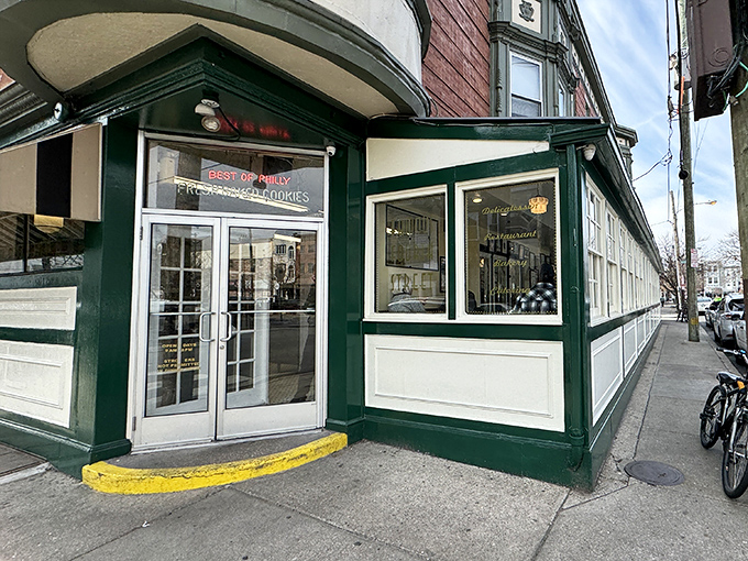 The iconic brick corner building housing Famous 4th Street Delicatessen stands like a time capsule in Philadelphia's Queen Village. Green-trimmed windows hint at the culinary treasures within.