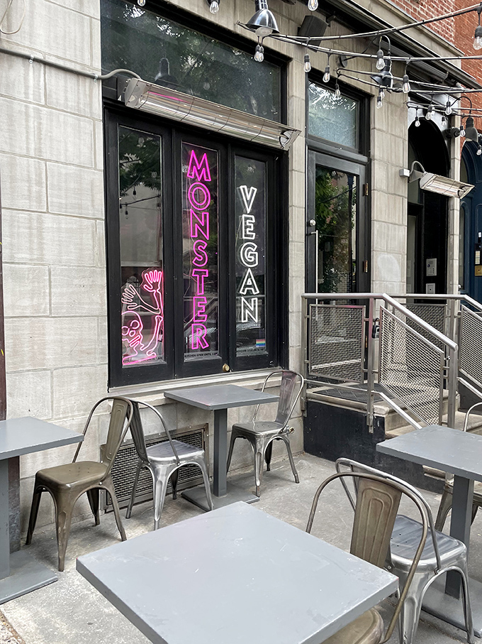 The neon-lit entrance to Monster Vegan beckons like a pink-hued beacon for the hungry and curious. Metal tables outside offer a perfect people-watching perch.