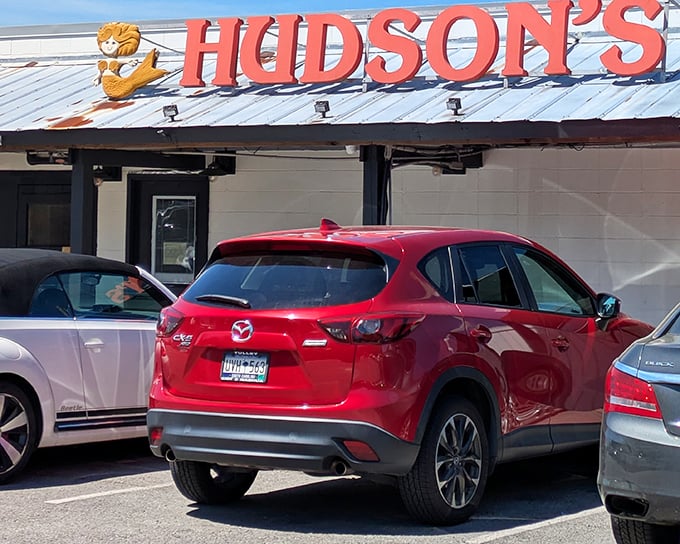 The iconic red Hudson's sign welcomes hungry visitors like a lighthouse beckoning seafood lovers to safe harbor. No fancy frills, just the promise of ocean-fresh delights.