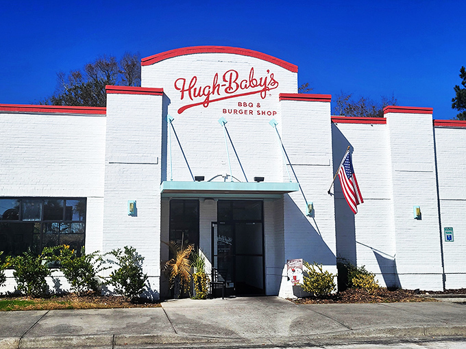 Hugh-Baby's white brick exterior with its bold red signage stands like a culinary lighthouse, beckoning hungry travelers with promises of Southern comfort.