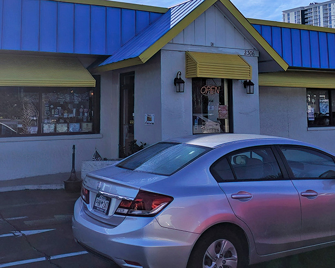 The iconic blue roof and yellow awnings of Harry's stand like a breakfast lighthouse, guiding hungry souls to pancake paradise.