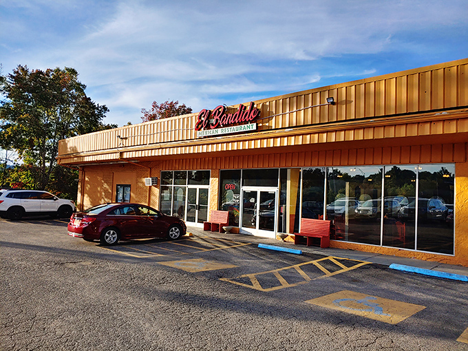 The golden glow of El Bandido's exterior promises culinary treasures within. Those red benches aren't just seating&mdash;they're the waiting room for flavor paradise.