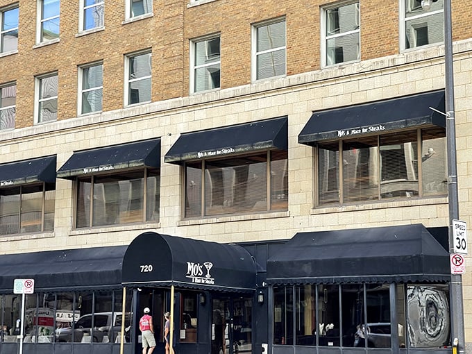 The classic black awnings of Mo's stand like elegant sentinels on Milwaukee's Plankinton Avenue, promising culinary adventures within these historic brick walls.