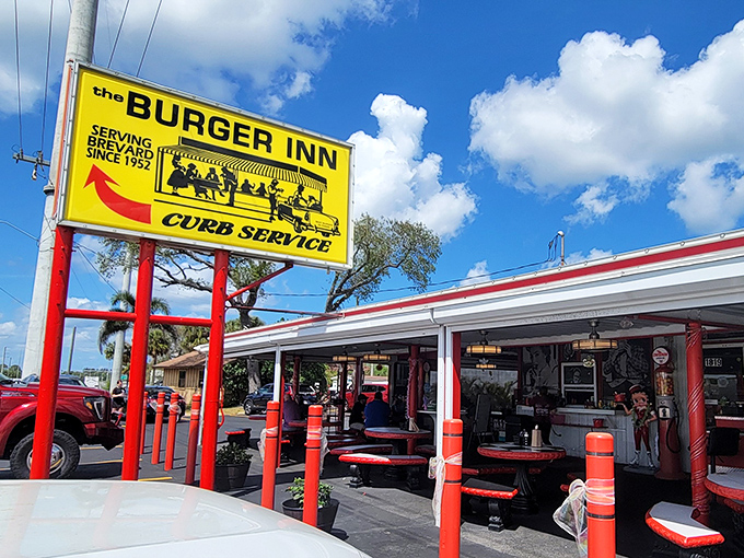 The bright yellow sign stands like a time machine on US-1, promising curb service and burger bliss since Eisenhower was signing legislation. 