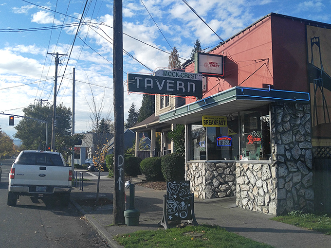 The iconic stone facade and vintage neon sign of Mock Crest Tavern stands as a beacon for breakfast seekers in North Portland.