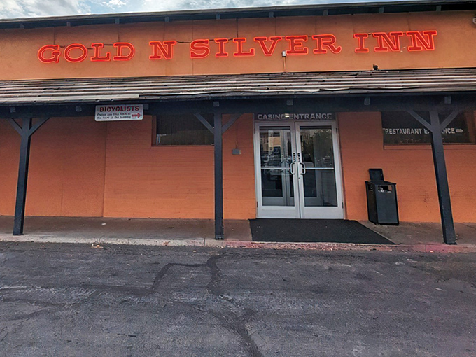 The iconic orange exterior with glowing red signage announces itself like Vegas neon for the hungry. No pretension, just breakfast promise.