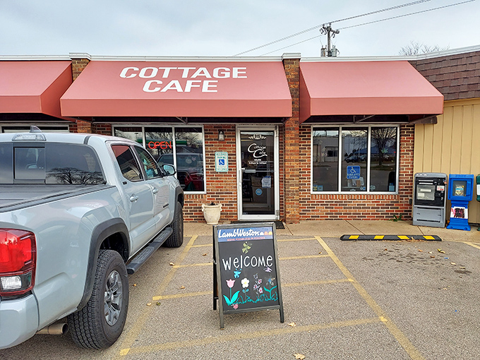The coral-colored awnings of Cottage Cafe stand like beacons of breakfast hope against Madison's skyline, promising comfort food salvation to hungry travelers.