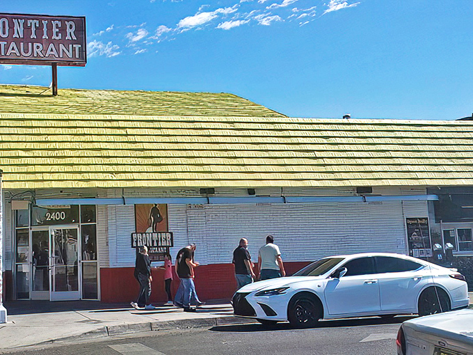 The iconic white and red exterior of Frontier Restaurant stands like a beacon of breakfast hope on Central Avenue, drawing hungry pilgrims daily.