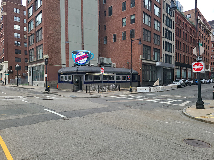 The iconic blue coffee cup sign beckons hungry souls to South Street Diner like a neon lighthouse in Boston's brick-lined Leather District.