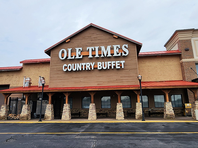 The rustic wooden facade of Ole Times Country Buffet beckons hungry travelers like a Southern siren song. Red roof, stone pillars, and all-you-can-eat promises await.