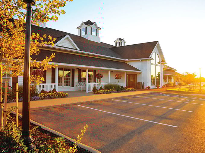 The classic white farmhouse exterior welcomes you like an old friend, complete with rocking-chair porch and blooming flowers that practically whisper "come on in."