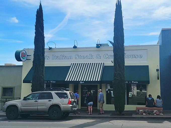 Classic Italian elegance meets small-town Arizona charm at Nic's exterior, where those cypress trees stand like sentinels guarding culinary treasures within.