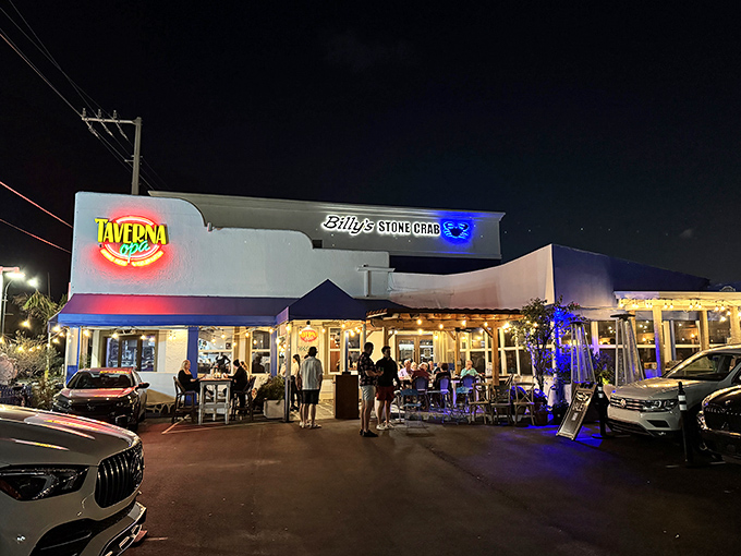 The sun-drenched exterior of Taverna Opa beckons like a Mediterranean mirage amid Florida's concrete jungle. Blue accents promise Greek delights inside.