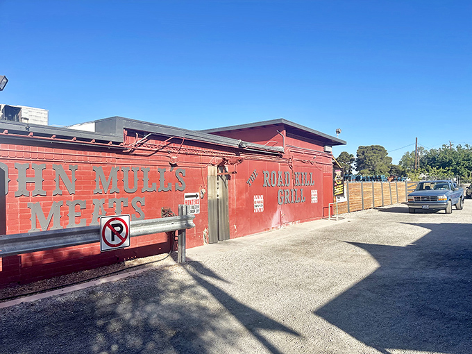 The bright red exterior of Road Kill Grill stands like a barbecue beacon in North Las Vegas, promising smoky delights within those unassuming walls. 