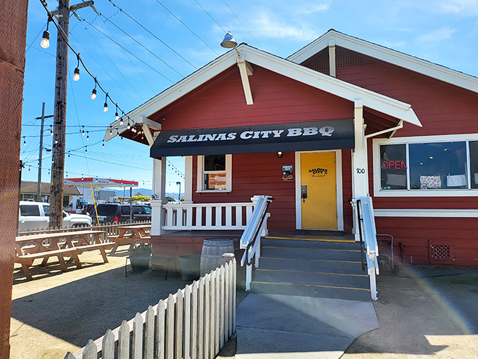 The little red barbecue house that could. With its cheerful yellow door and string lights, this unassuming spot is where smoke dreams come true.