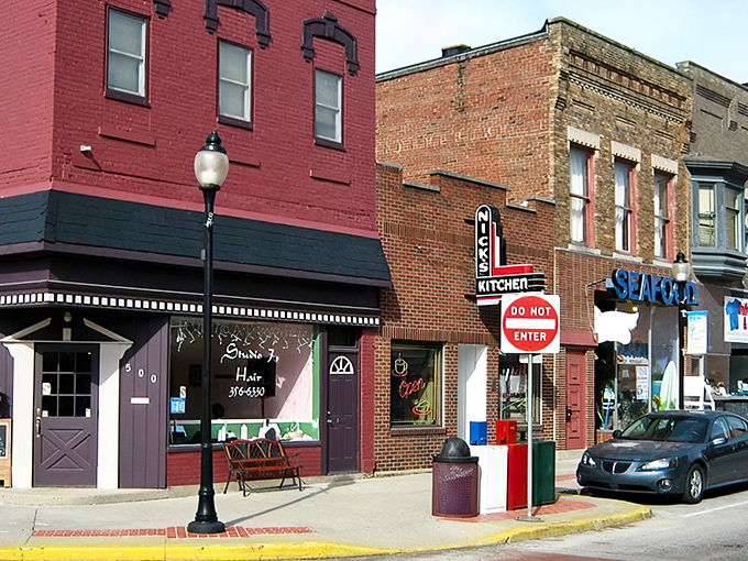The iconic neon sign of Nick's Kitchen stands as a beacon of comfort food in downtown Huntington, promising delicious memories since 1908.