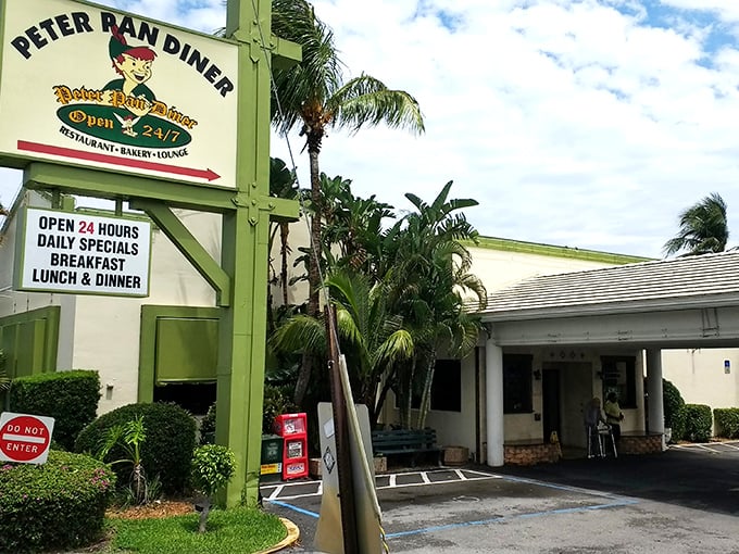 The iconic green sign beckons like a culinary lighthouse amid Florida palms. Peter Pan Diner's exterior promises comfort food magic from 6am to midnight.
