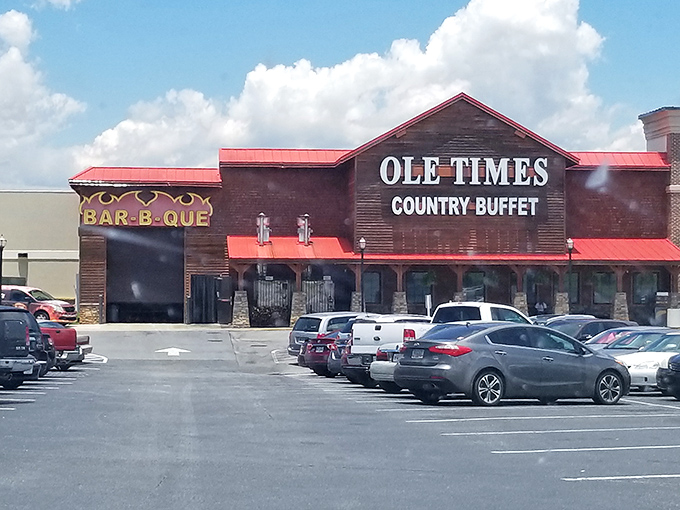 The rustic wooden facade of Ole Times Country Buffet beckons hungry travelers like a Southern siren song. Red roof, stone pillars, and all-you-can-eat promises await.
