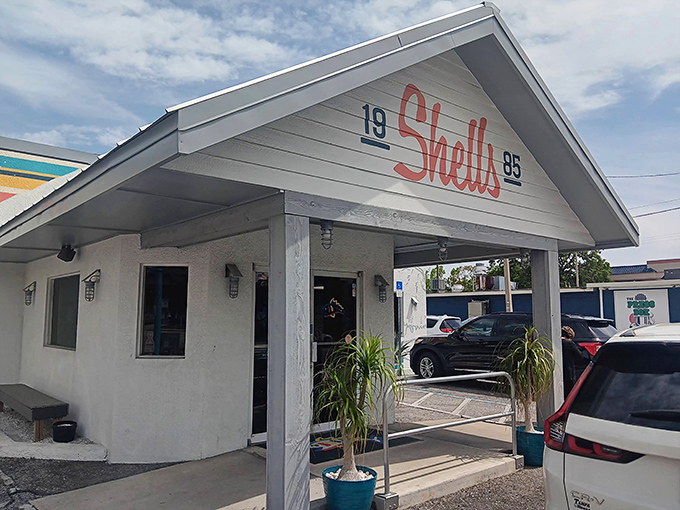 The iconic Shells Seafood storefront welcomes hungry visitors with its distinctive coral-red script and coastal charm. Florida dining at its unpretentious best.