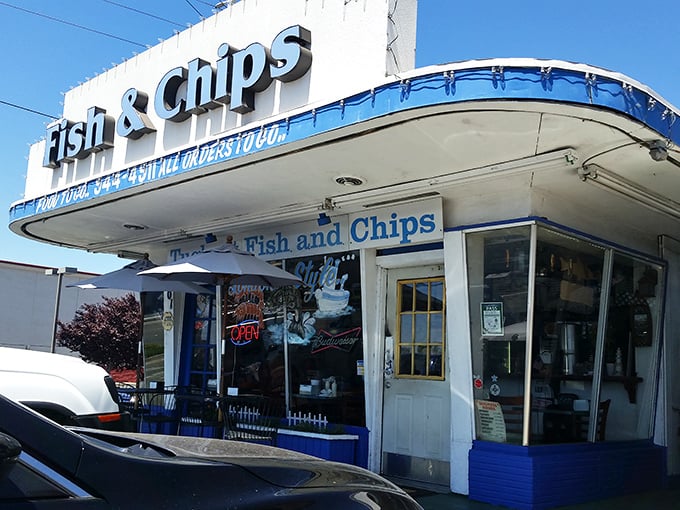 The iconic blue-trimmed exterior of Tugboat Fish & Chips stands like a maritime beacon in suburban Carmichael, promising seafood treasures within its modest walls.