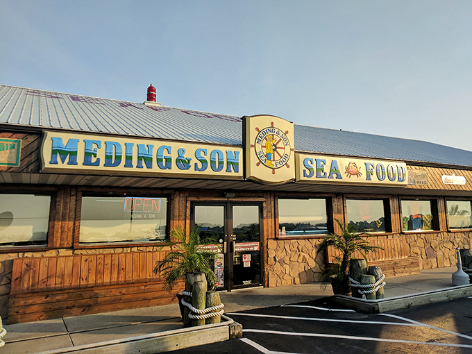 The blue and yellow sign beckons like a lighthouse for hungry sailors. Meding's weathered wooden exterior promises authentic seafood without pretension.
