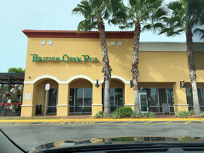 A slice of Britain basks in Florida sunshine. The British Open Pub's cheerful yellow exterior and teal signage create an inviting cultural crossroads where palm trees meet pub tradition.