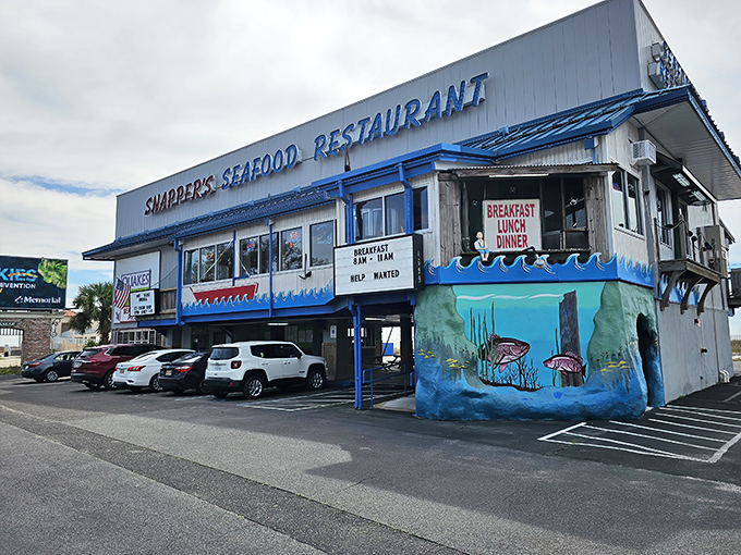 Snapper's iconic blue-trimmed exterior stands like a beacon for seafood lovers, with parking cleverly tucked underneath&mdash;Gulf Coast practicality at its finest.
