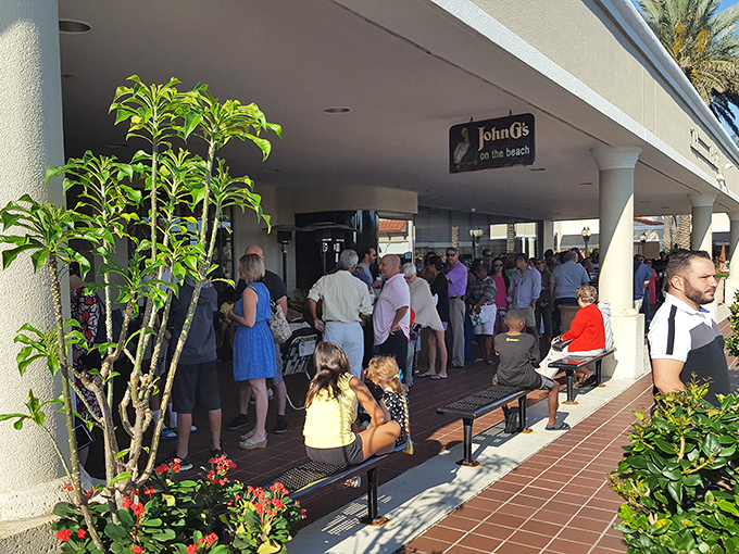 The line forms early at John G's, where patient food pilgrims gather under Florida sunshine. Worth every minute of the wait!