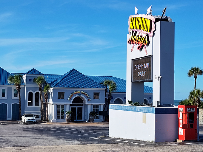 The iconic blue roof and weathered wood exterior of Harpoon Harry's stands as a beacon for hungry beachgoers seeking seafood salvation.