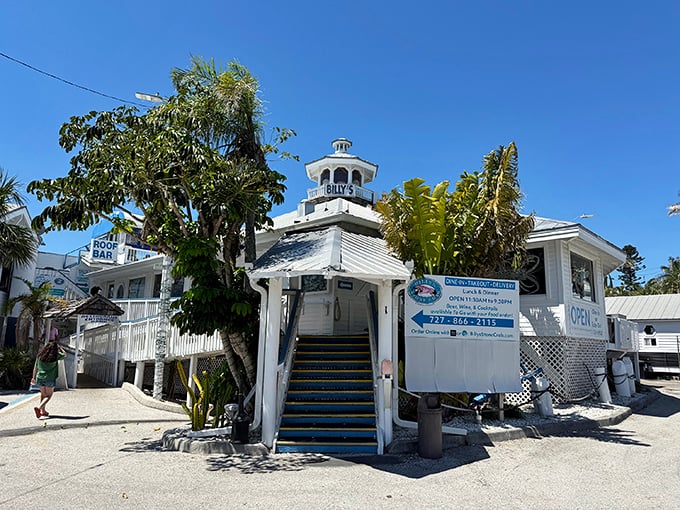 The iconic white lighthouse-topped entrance to Billy's Stone Crab beckons seafood lovers up those blue steps like a siren call to paradise.