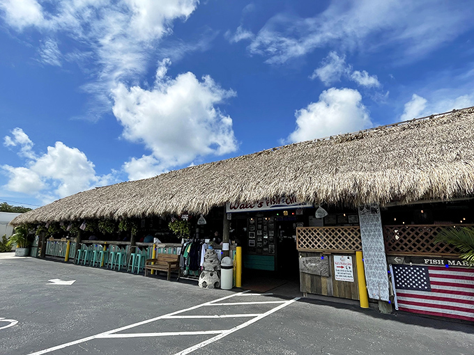 The thatched-roof paradise of Walt's Fish Market beckons like a mirage on Tamiami Trail, promising seafood treasures beneath its tropical canopy.