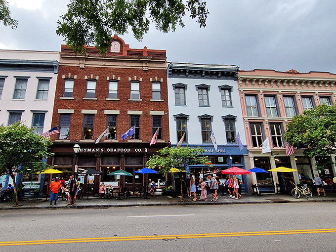 The iconic blue storefront of Hyman's glows with promise as evening falls, flags fluttering like a patriotic welcome committee for hungry visitors.