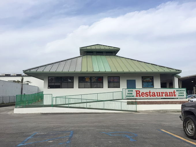 The green-roofed sanctuary of breakfast dreams stands proudly against the Florida sky, promising honest food without the fuss.