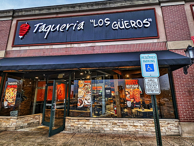 The iconic black sign with white lettering and red spiral logo beckons hungry travelers like a lighthouse for those lost in a sea of mediocre Mexican food.