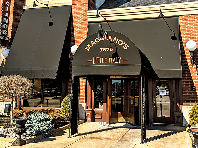 The welcoming brick exterior of Maggiano's Little Italy, where hanging flower baskets and classic awnings promise Italian comfort before you even step inside.